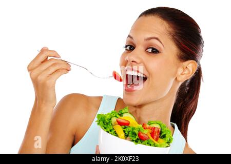 She enjoys a healthy diet. Young woman smiling while eating a fresh ...