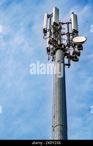 5G transmitter mast against the blue sky between the trees Stock Photo ...