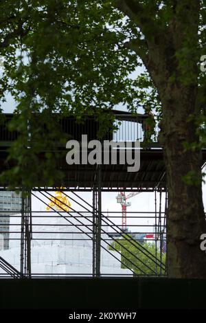 Temporary structures and workers are silhouetted against the Victoria ...