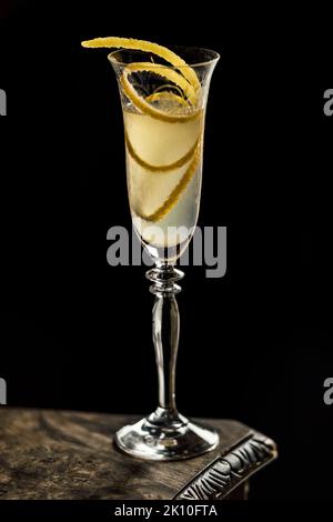 A drink of lemon and lime in an elegant glass on a blue background with ...