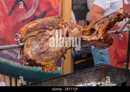 Process of cooking pork on spit at summer street food market Stock ...