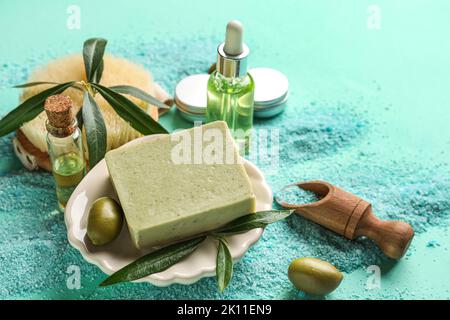 Soap bar, green olives and sea salt on color background Stock Photo - Alamy