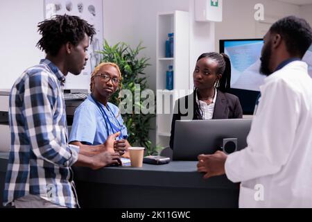 African american receptionist helping patient with neck collar at ...