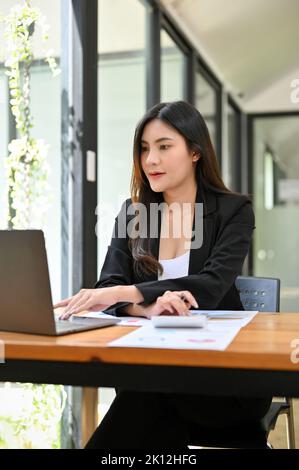 Female accountant analyzing financial data at laptops in bright home ...