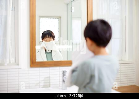 Japanese kid wiping face with towel at home Stock Photo - Alamy