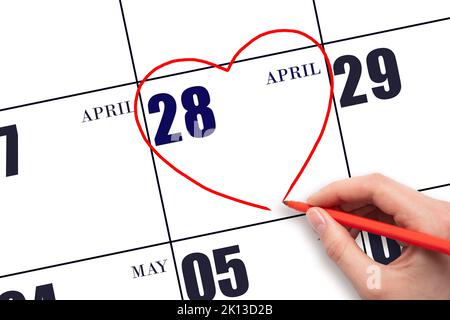 28th day of April. A woman's hand drawing a red heart shape on the ...