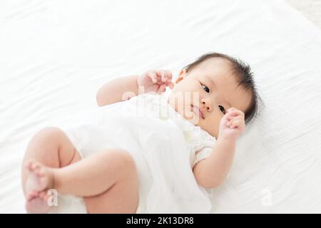 Japanese Baby Girl Lying Raising Hands On White Blanket Indoor Stock ...