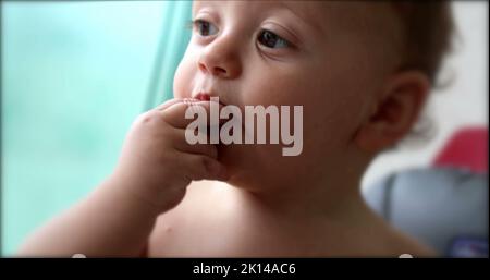 Cute baby portrait eating and spitting food. Close-up infant child face ...