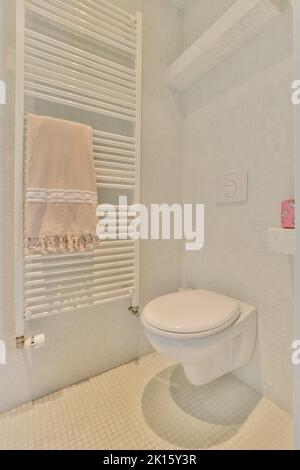 Washroom with a radiator next to the toilet and a shelf above it Stock ...