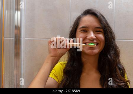 Young woman brushing her teeth in the bathroom Stock Photo - Alamy