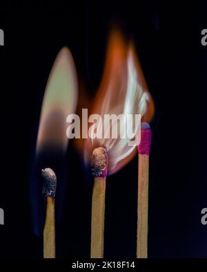 Three matches, one catching fire from the other. Concept: teamwork ...