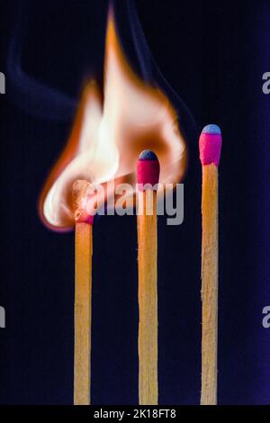 Three matches, one catching fire from the other. Concept: teamwork ...