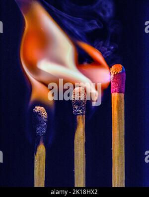 Three matches, one catching fire from the other. Concept: teamwork ...