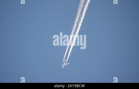 Single small airplane flying diagonal on the minimalist background of ...