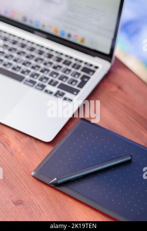 Graphic designer's workplace. Laptop and graphics tablet on a wooden ...
