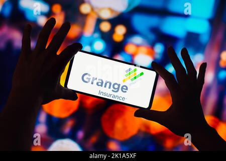 In this photo illustration, the Grange insurance logo is seen displayed ...