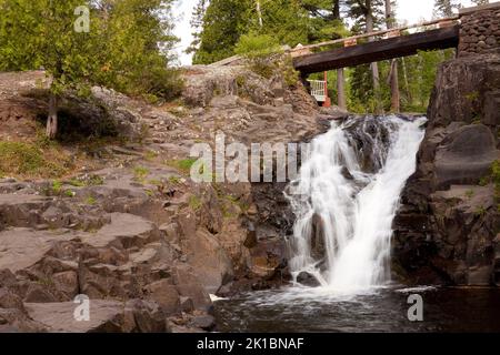 A waterfall under a footbridge on Amity Creek Stock Photo - Alamy