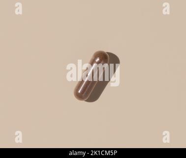 Brown Medical capsule on light beige top view, hard shadows. Taking ...
