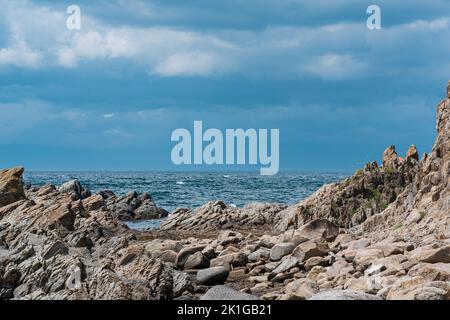 sharp jagged basalt rocks on the sea coast, Cape Stolbchaty on Kunashir ...