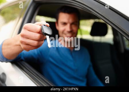 Dont forget the spare key. Smiling male sitting in his car holding up ...