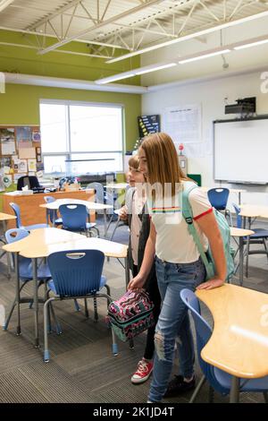 Smiling students leaving classroom while walking together Stock Photo ...