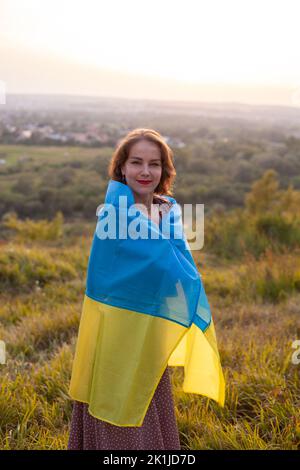 Happy free ukrainian woman with national flag on dramatic sky ...