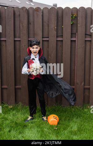 asian boy in vampire king costume growling while showing frightening ...