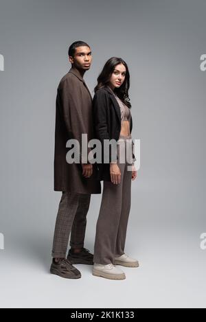 stylish interracial couple in autumnal outfits and trendy sunglasses ...