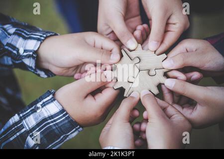 Hands assembling jigsaw puzzle, put pieces together Stock Photo - Alamy