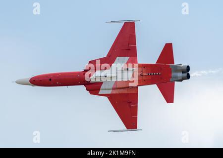 A red jet airplane of the Swiss Airforce performing stunts during an ...