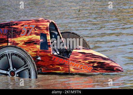 swamp buggy moving through water, action, close-up, spectators behind ...