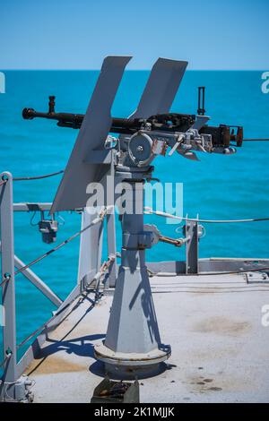 Color image of an automated machine gun on the deck of a military ship ...