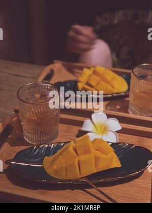 Closeup shot of a beautifully cut mango on a plate with berries and ...