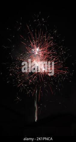 A vertical shot of a glowing firework in the sky at night Stock Photo ...