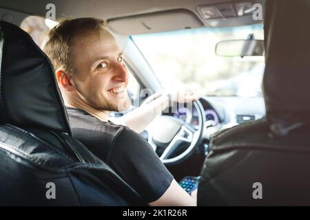 Self-employed russian smiling driver in his car taxis or works on ...