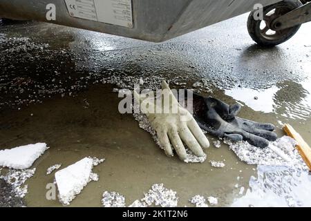 Gloves of a construction worker in a puddle Stock Photo - Alamy