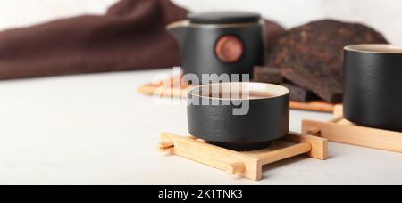 Stand with cup of puer tea on white background, closeup Stock Photo - Alamy