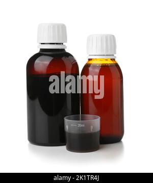 Bottles of syrup and measuring cup on wooden table, space for text ...