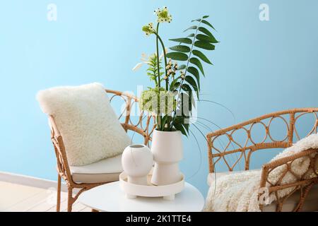Vases with beautiful ikebana on table in stylish living room Stock ...