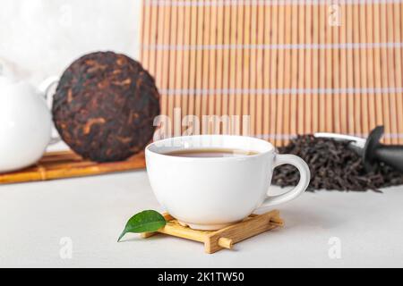 Stand with cup of puer tea on white background, closeup Stock Photo - Alamy