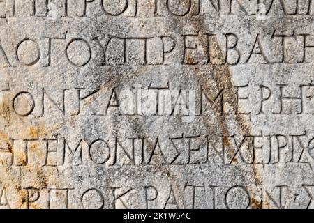 A closeup of an ancient Greek inscriptions on the pillar of the Roman ...