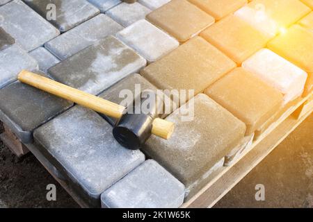 Defocus paving hammer. Stack of paving stones. Garden brick pathway ...