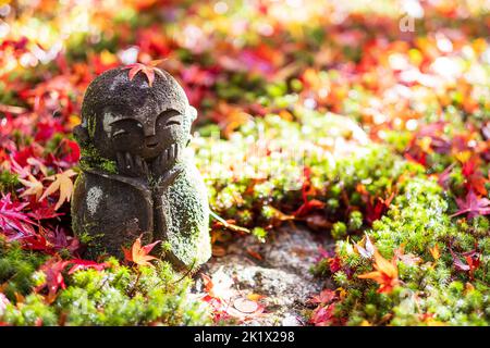 Japanese Jizo sculpture doll with falling Red Maple leaf in Japanese ...