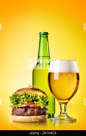 Beer glass and hamburger over color background Stock Photo - Alamy