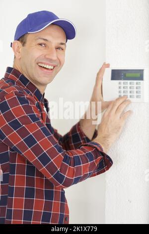 senior workman programming electronic keypad Stock Photo - Alamy