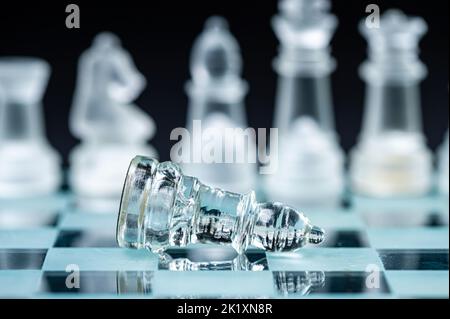clear glass, transparent chess pieces on a checkerboard, selective ...