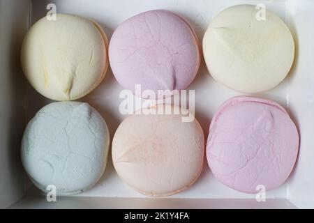 Six colorful handmade marshmallows in a cardboard box on the table ...