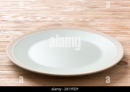 Perspective view of empty light plate on wooden background. Empty space ...