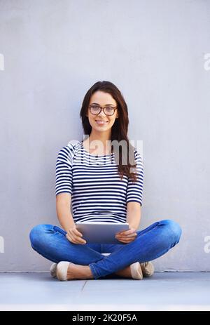 Young woman model sitting with tablet pc and painting with pencil ...