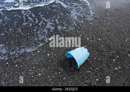 Blue plastic toy bucket partially buried in the sand Stock Photo - Alamy